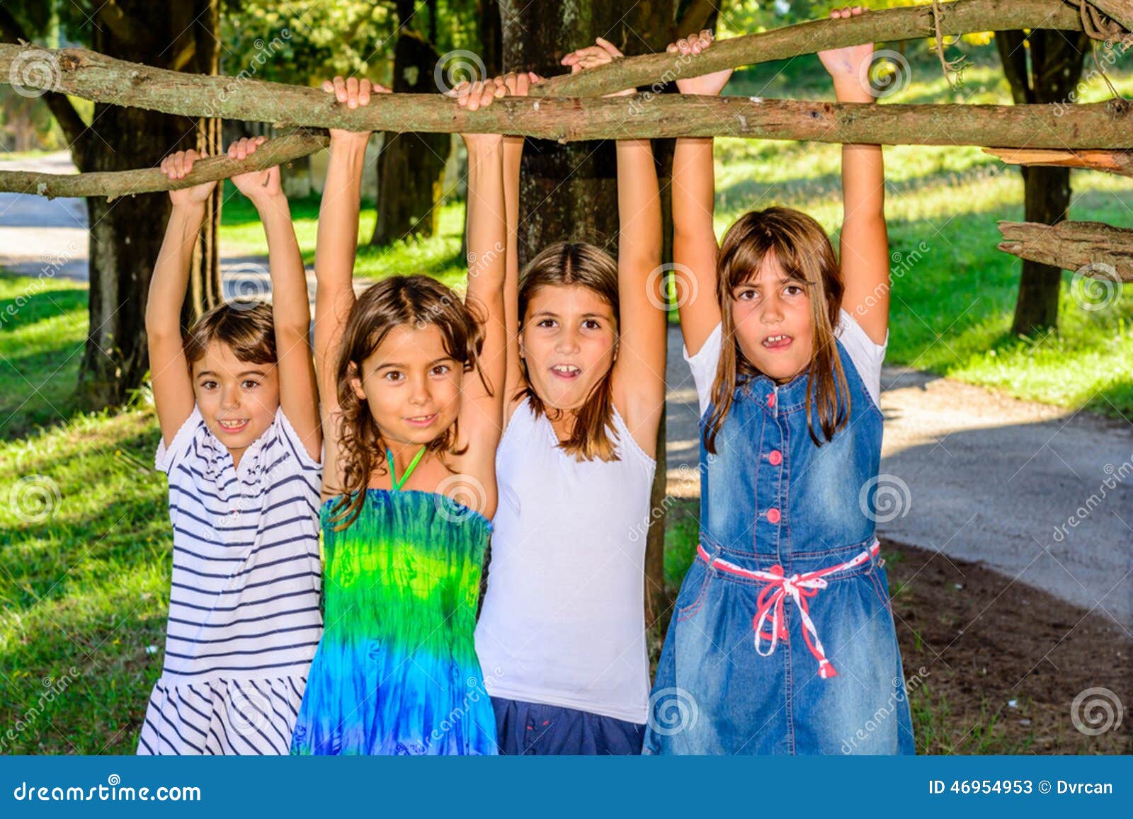 Four Little Girls Playing In The Park And Hanging On The Tree Royalty ...