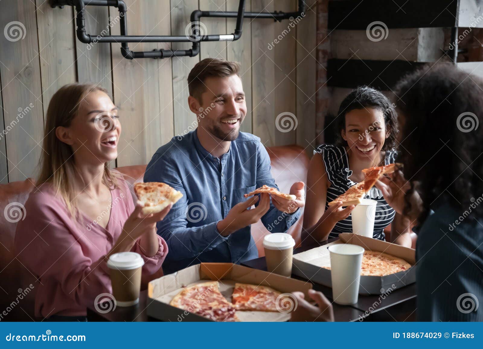 Four Multiethnic Best Friends Eat Pizza Drink Coffee In Cafe Stock
