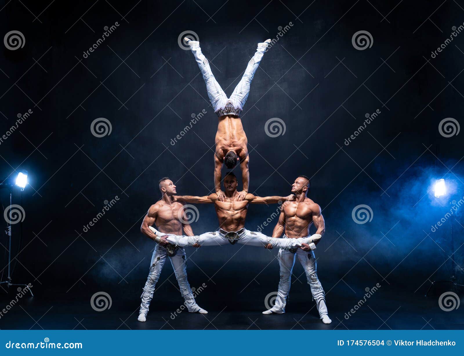 Four Muscular Man Perform Difficult Acrobatic Tricks on Black Studio ...