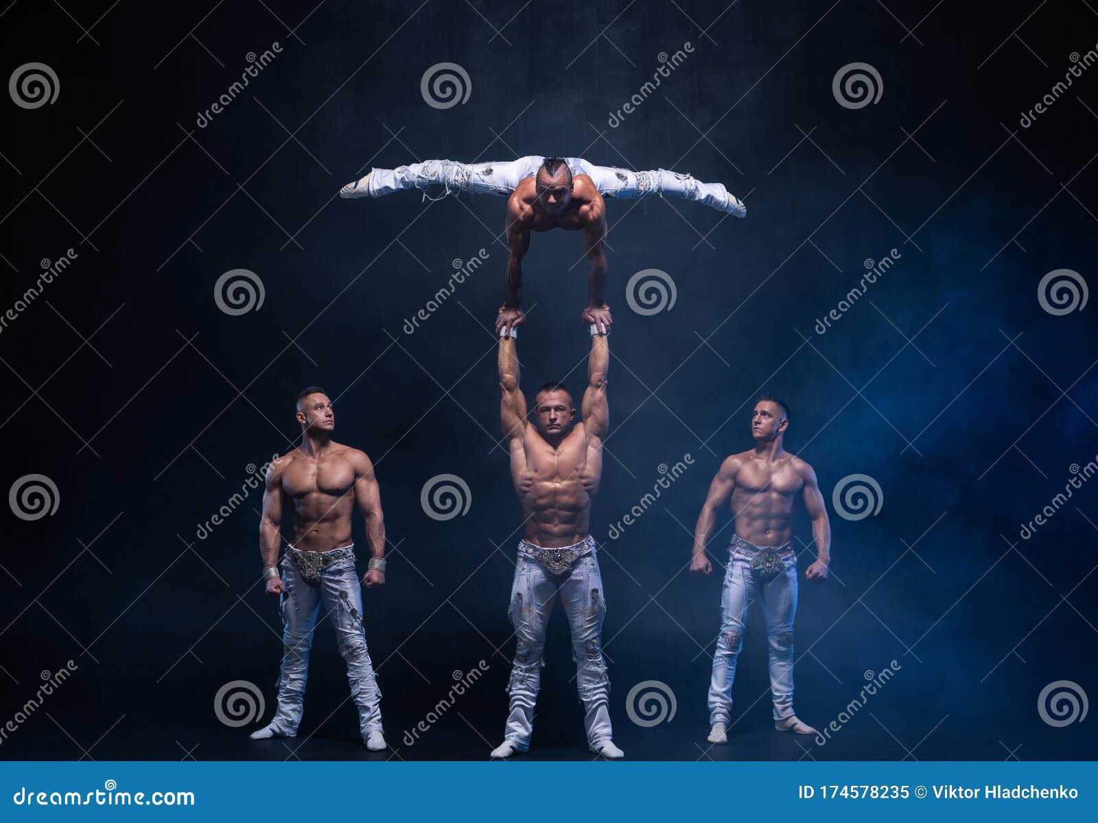 Four Muscular Man Perform Difficult Acrobatic Tricks on Black Studio ...