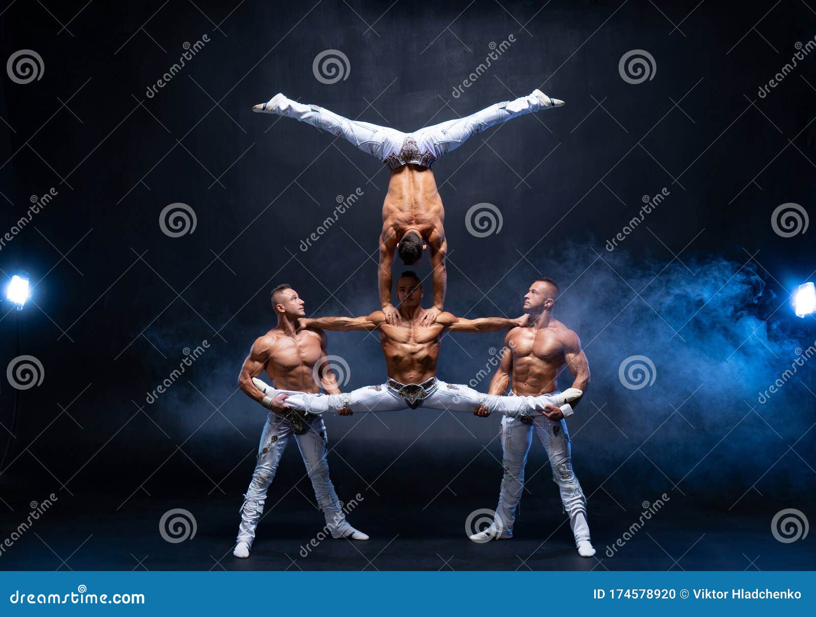 Four Muscular Man Perform Difficult Acrobatic Tricks On Black Studio ...