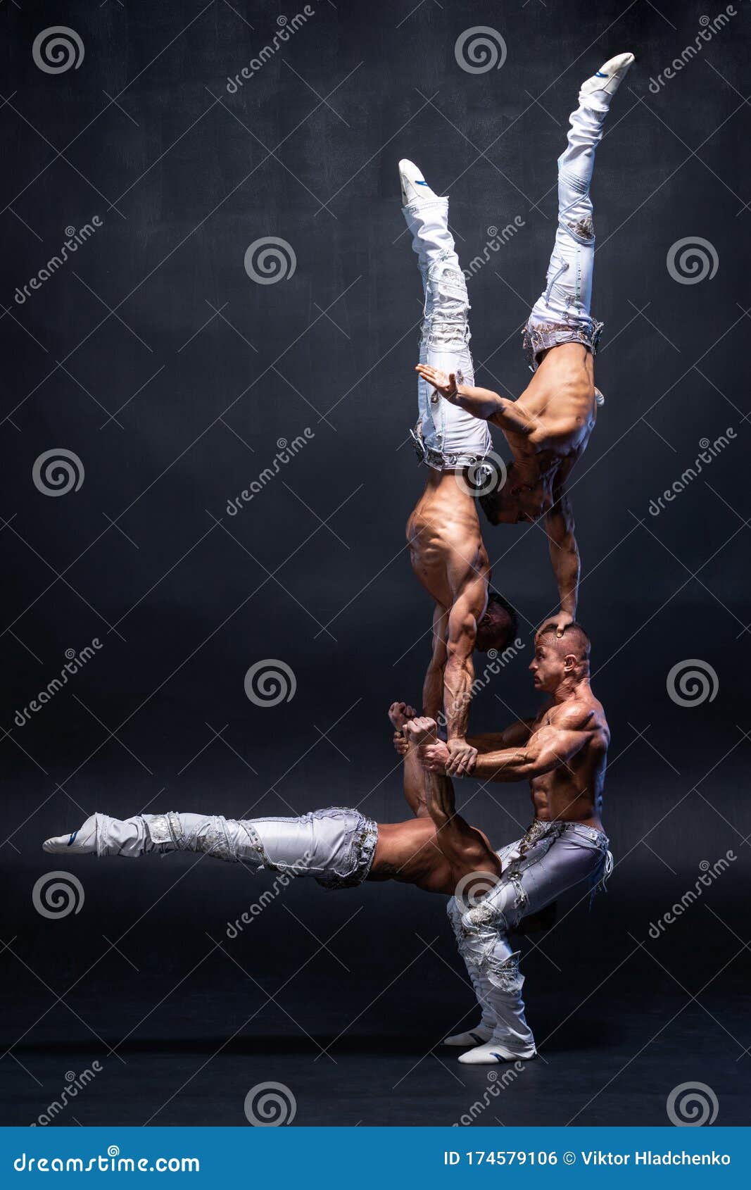 Four Muscular Man Perform Difficult Acrobatic Tricks on Black Studio ...