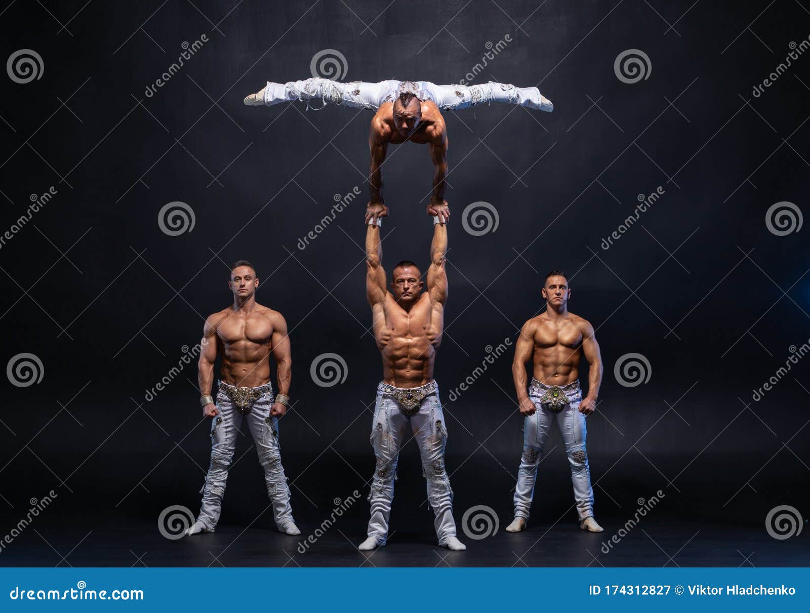 Four Muscular Man Perform Difficult Acrobatic Tricks on Black Studio ...