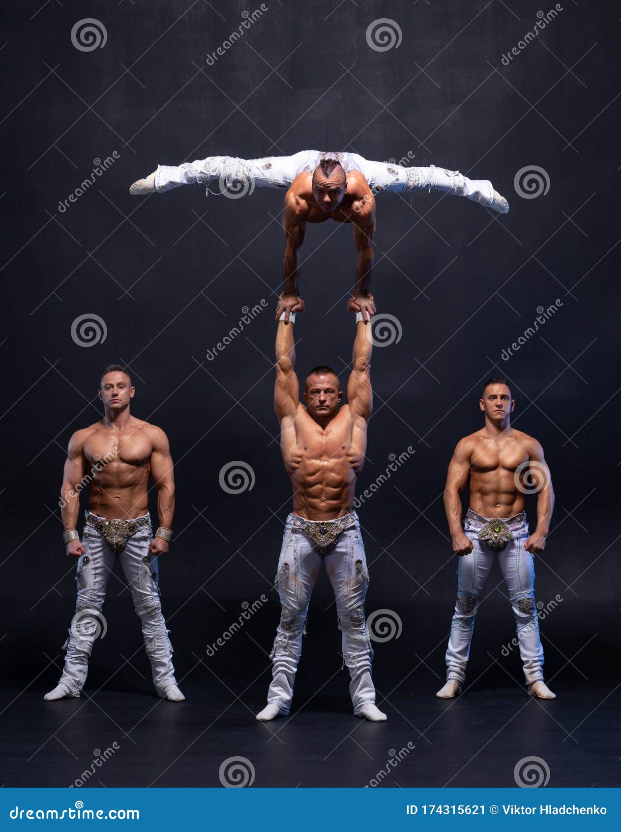 Four Muscular Man Perform Difficult Acrobatic Tricks on Black Studio ...
