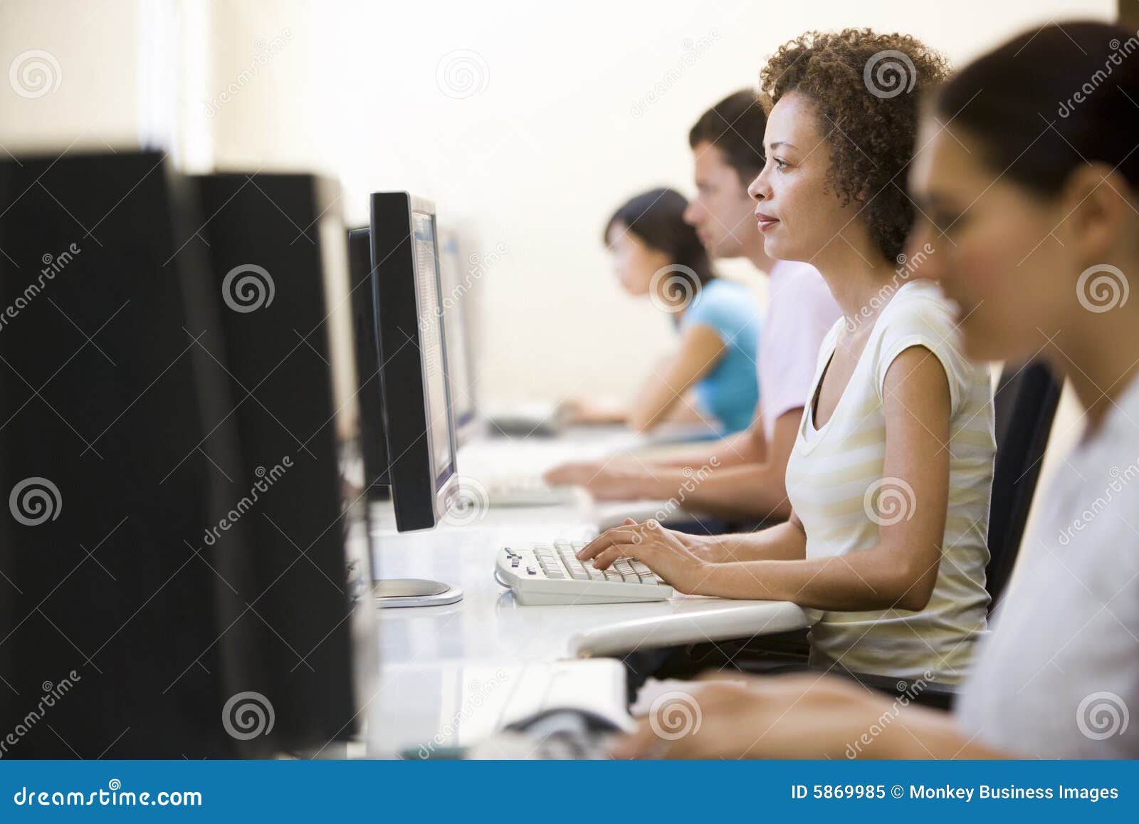 Four People Sitting in Computer Room Typing Stock Image - Image of ...