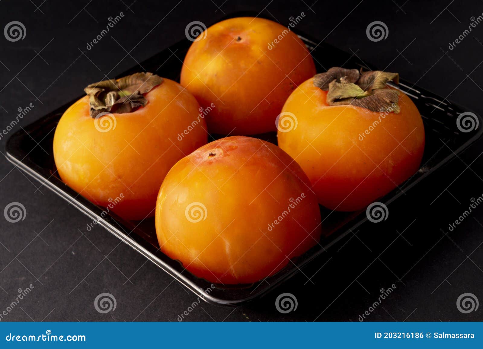 Four Persimmons on Black Background Stock Photo - Image of food, black ...