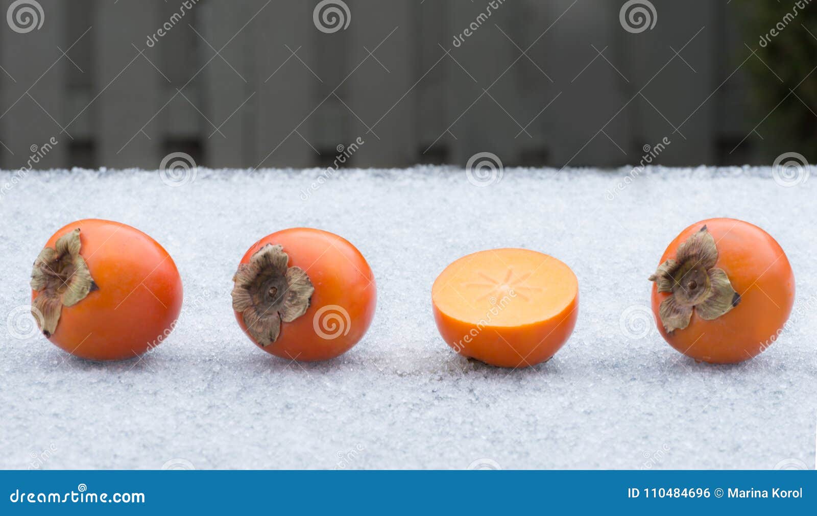 Four Persimmons on Ice. Half of Fruit and Three Whole Persimmons Stock ...