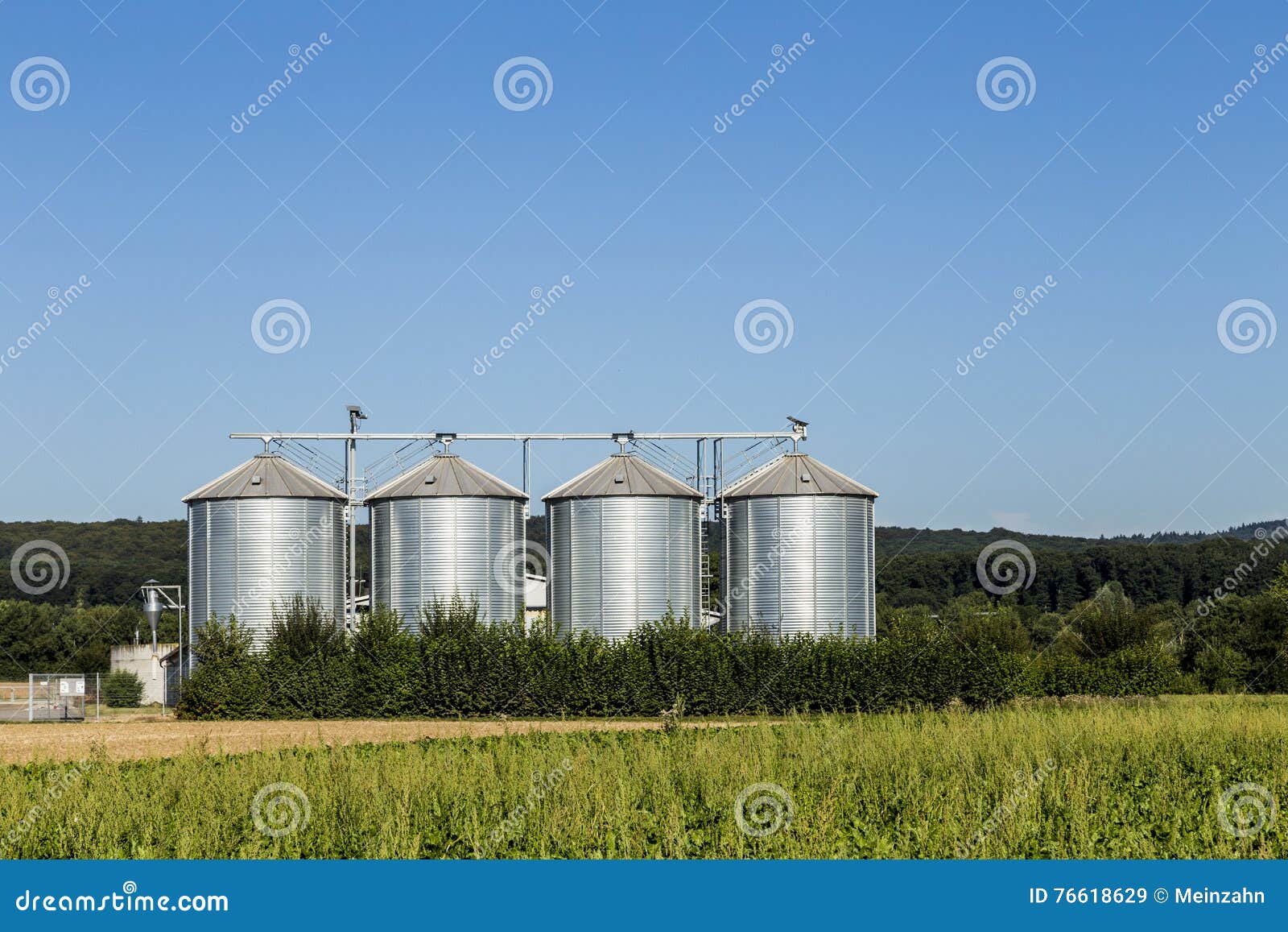 Four Silver Silos in Field Under Blue Sky Stock Image - Image of ...