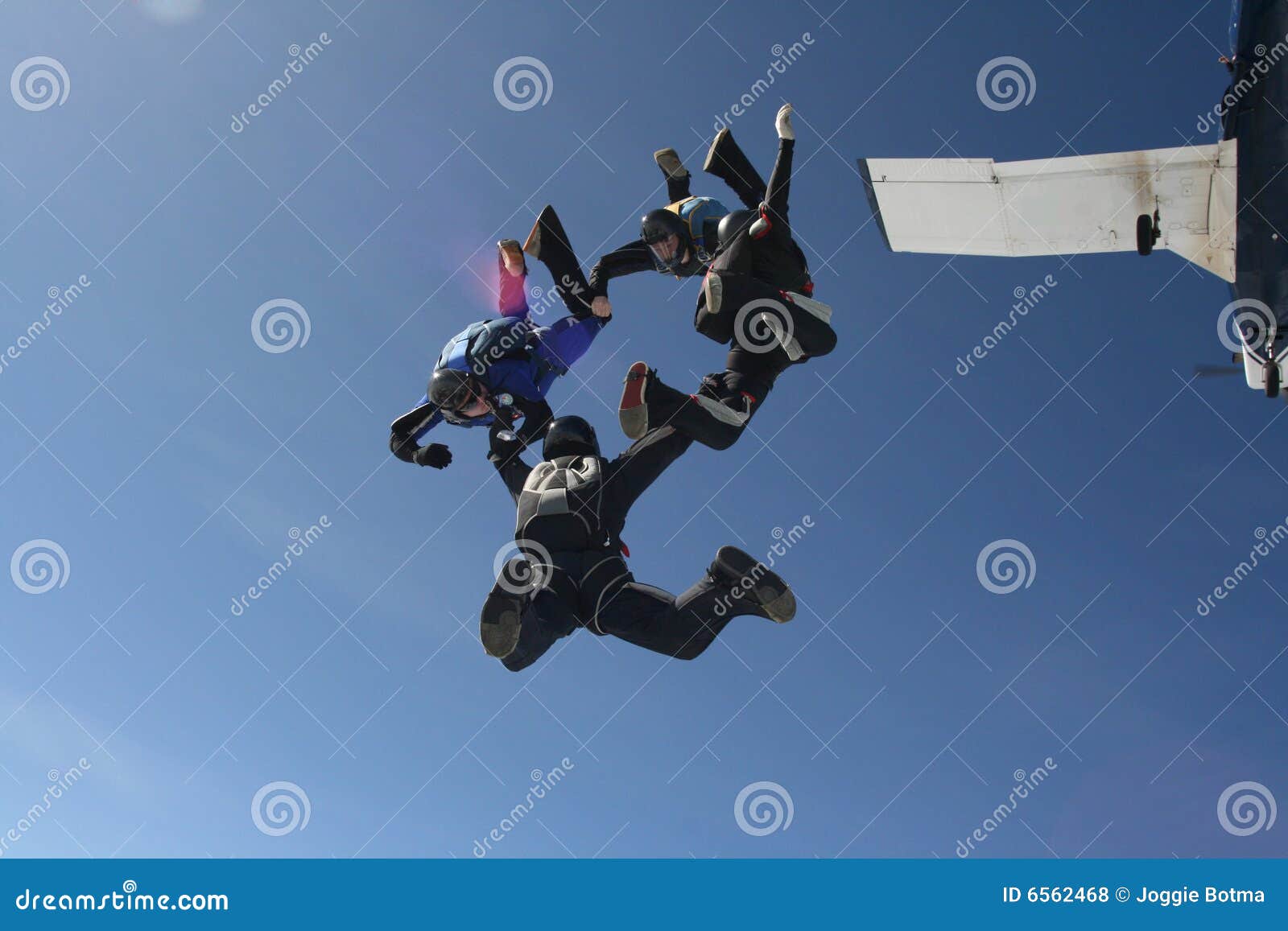 Four Skydivers Exit a Plane Stock Photo - Image of turning, falling ...