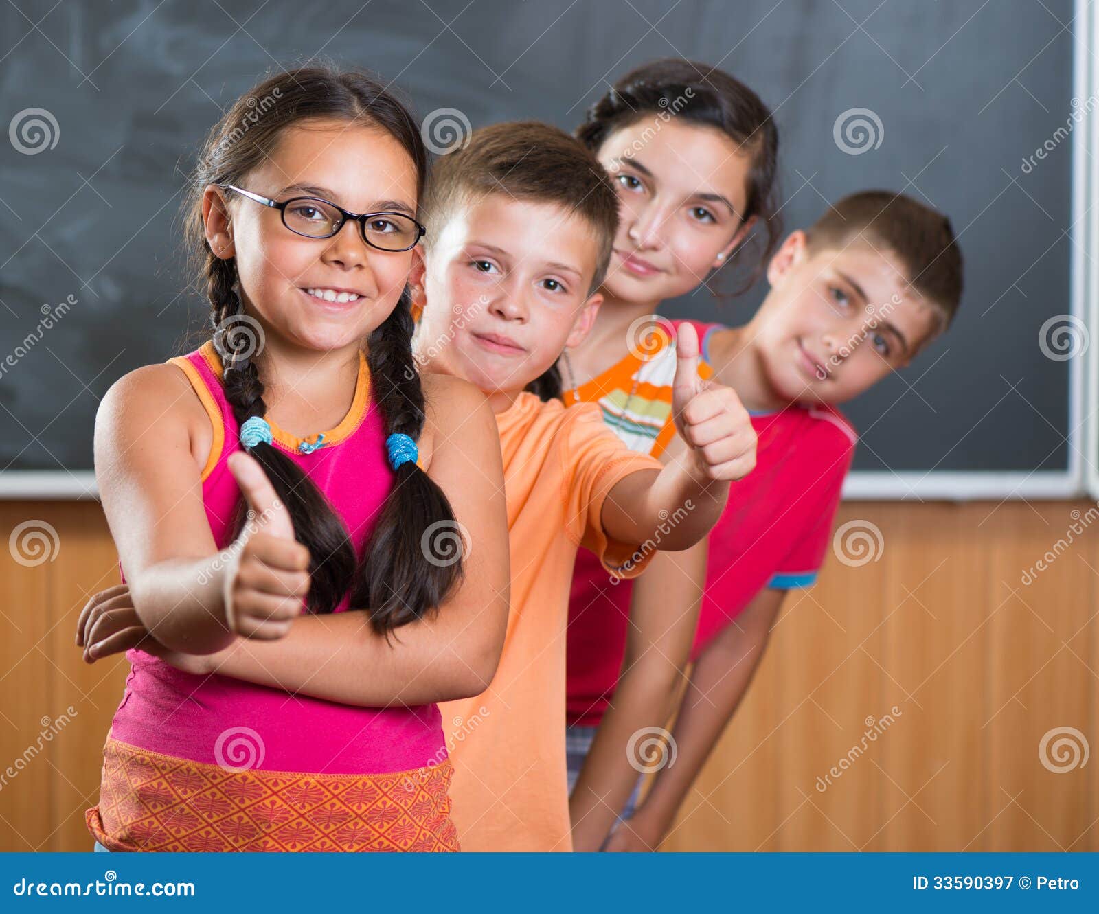 Four Smiling Schoolchildren Standing in Classroom Stock Image - Image ...