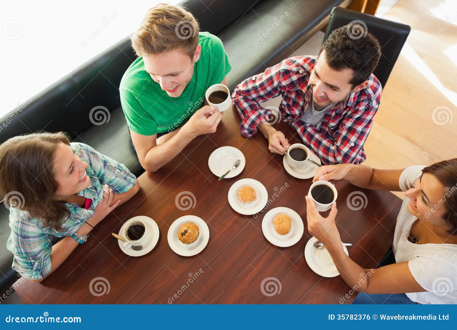 Four Smiling Students Having a Cup of Coffee Chatting Stock Photo ...