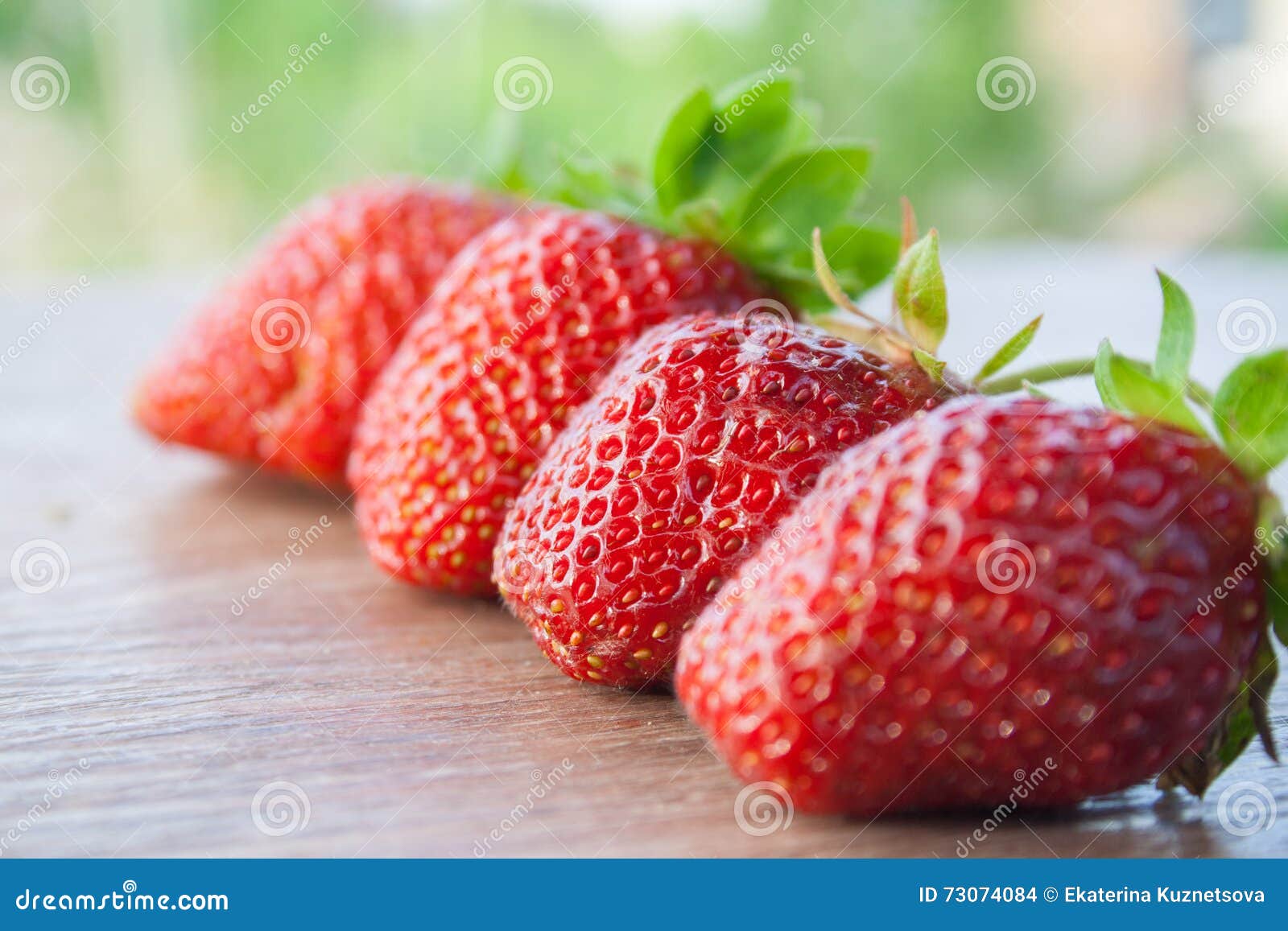 Four strawberries in a row stock photo. Image of seasonal - 73074084