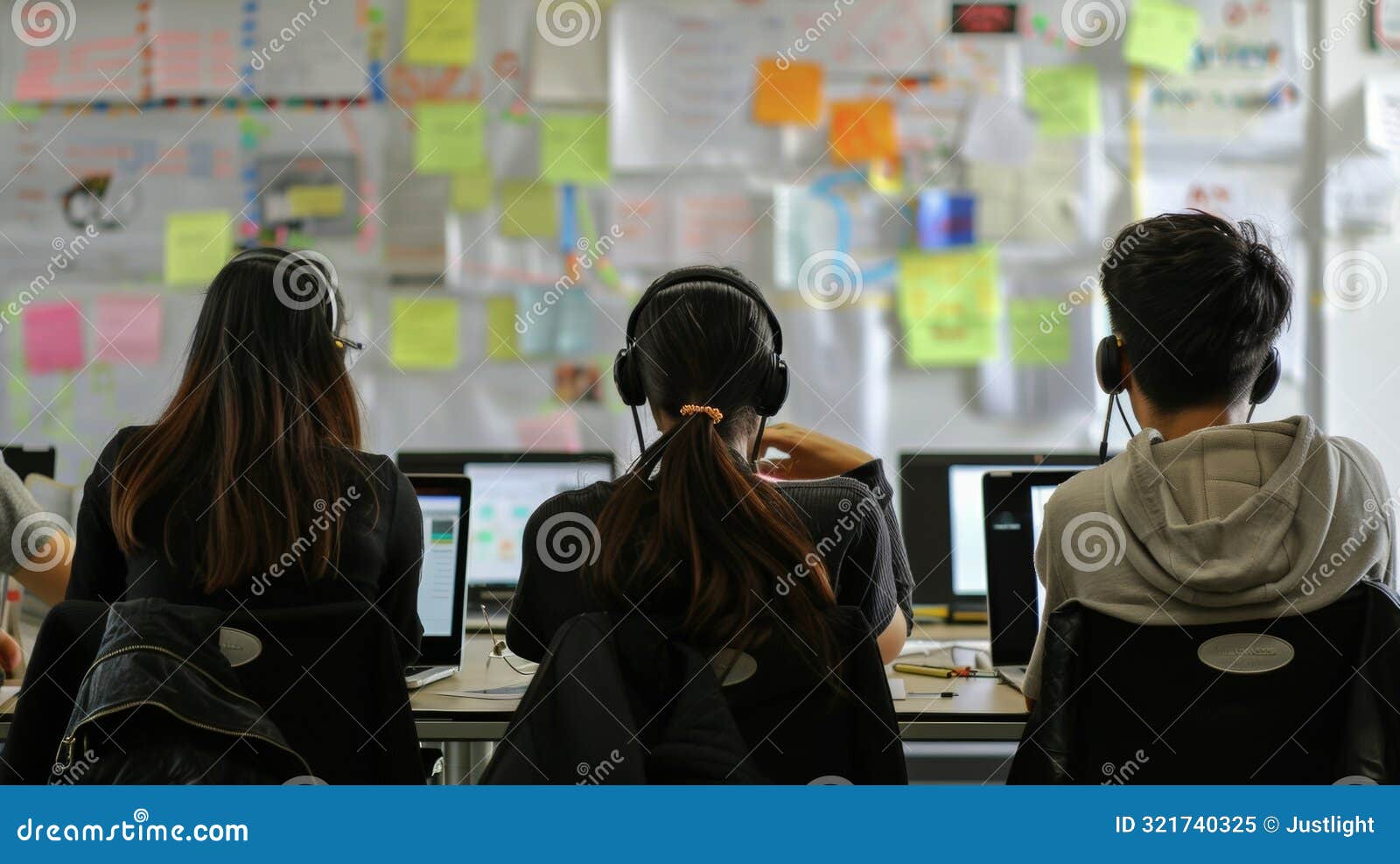 Four Students All Facing Away from the Camera Intently Typing on ...