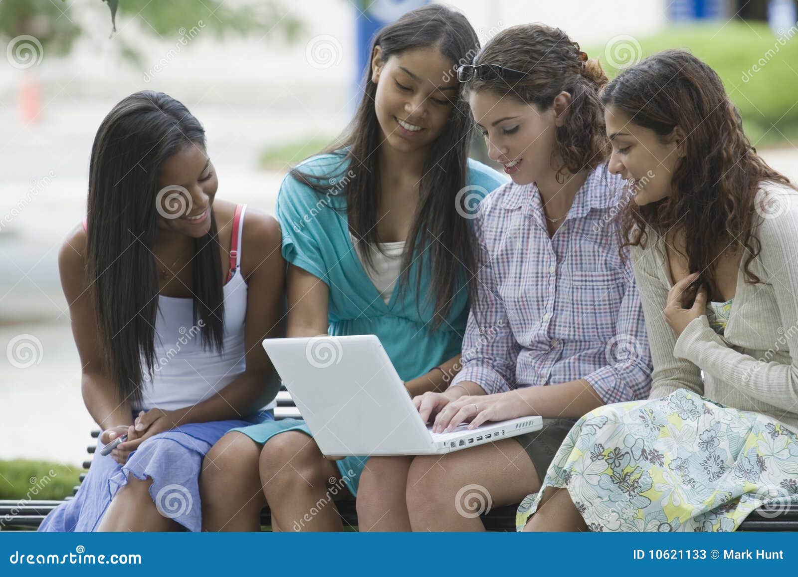 Four teens on a laptop stock image. Image of four, color - 10621133
