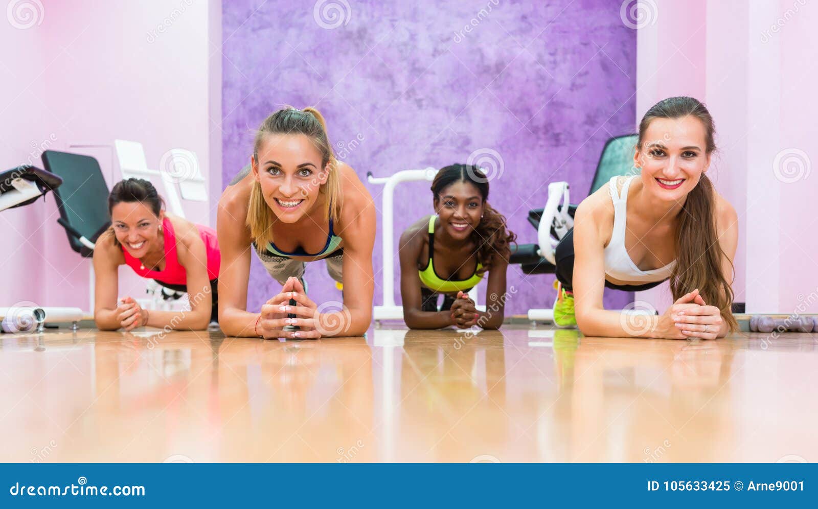 Four Women Practicing Forearm Plank Position during Group Class Stock ...