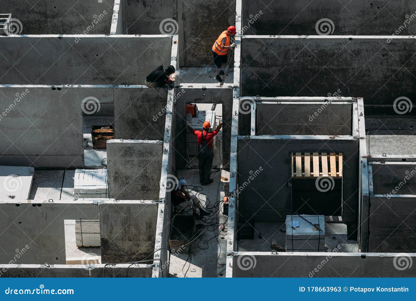 Four Workers on the Top Floor of the Building are Installing Concrete ...