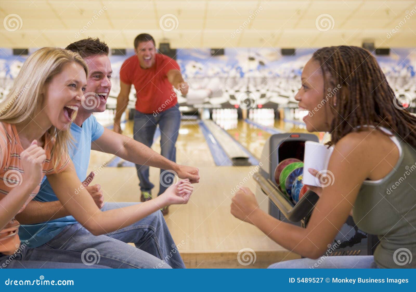 Four Young Adults Cheering in a Bowling Alley Stock Image - Image of ...