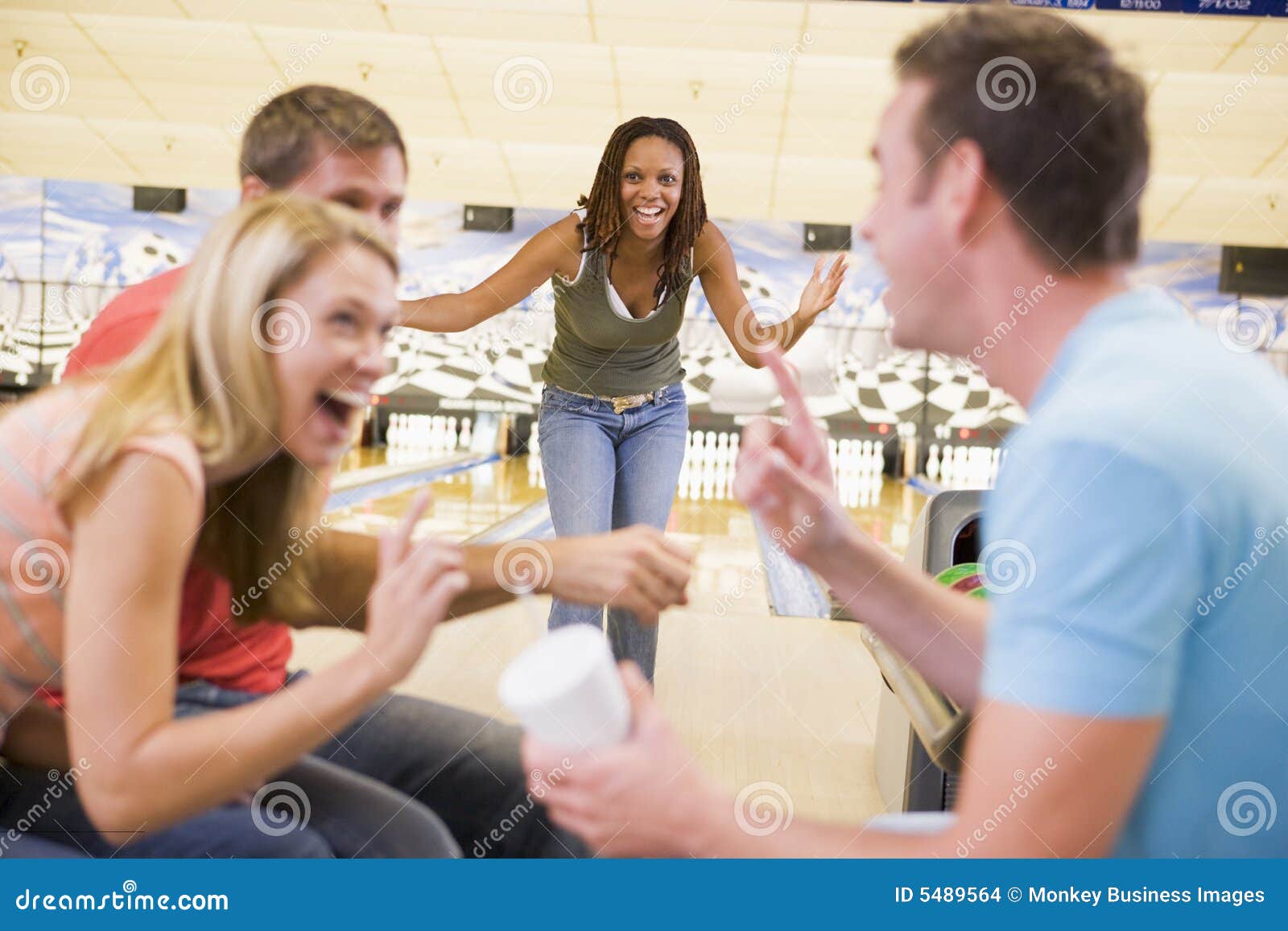 Four Young Adults Laughing at a Bowling Alley Stock Photo - Image of ...