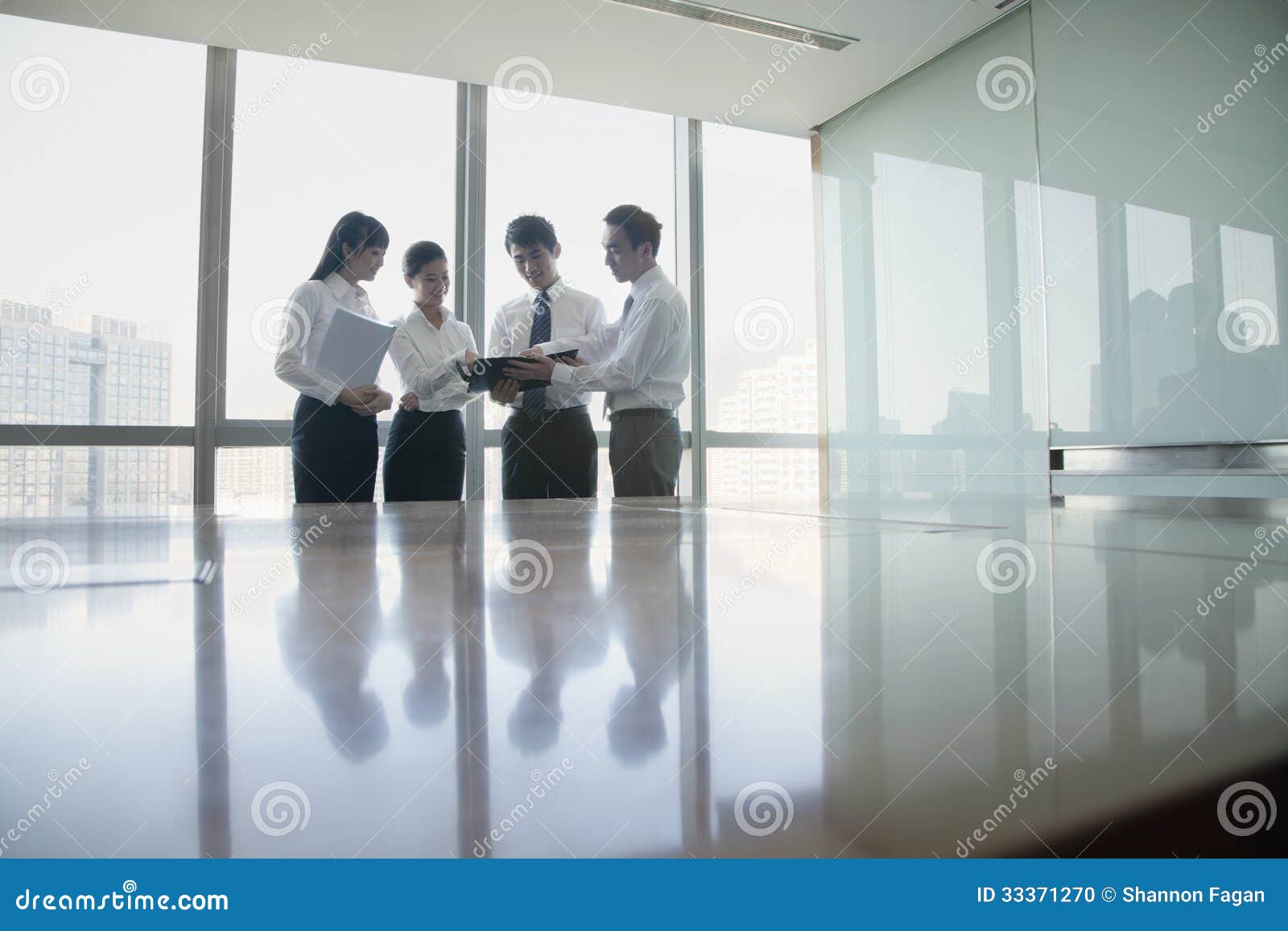 Four Young Business People Standing by Conference Table Stock Photo ...