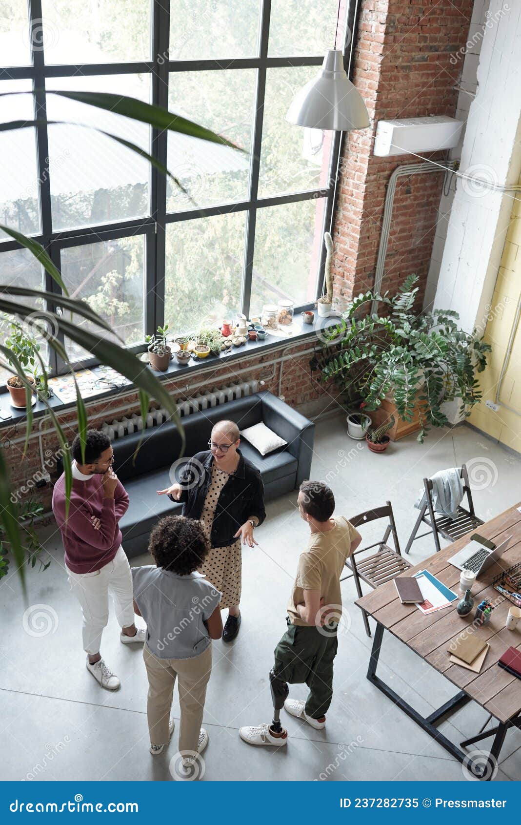 Four Young Contemporary Office Workers Standing by Table during ...