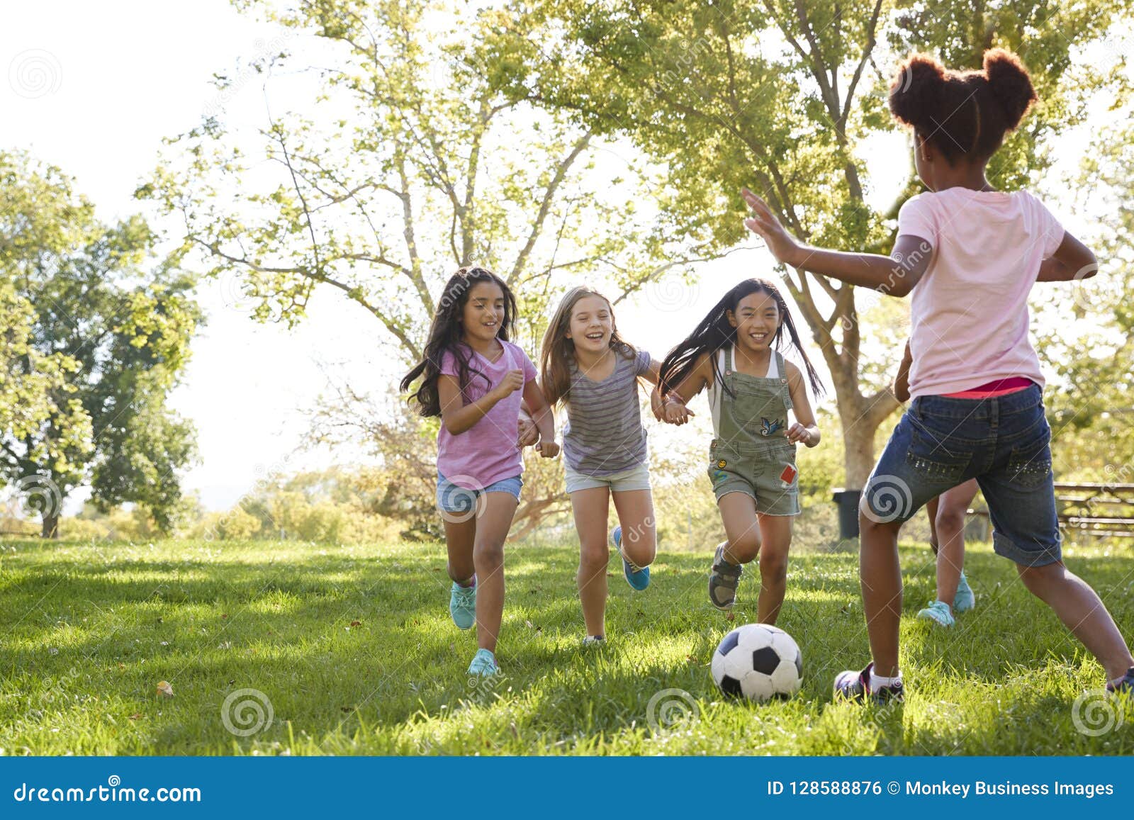 Four Young Girlfriends Running after a Football in the Park Stock Photo ...