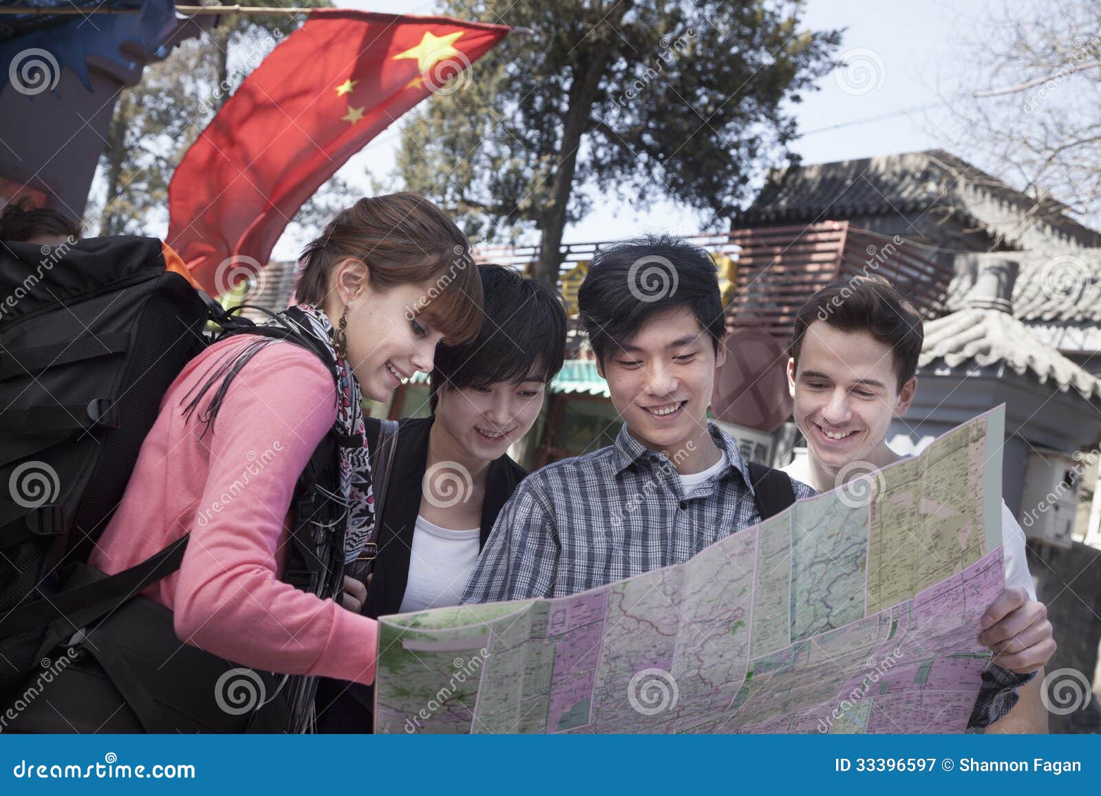 Four Young People Looking at Map. Stock Image - Image of direction ...