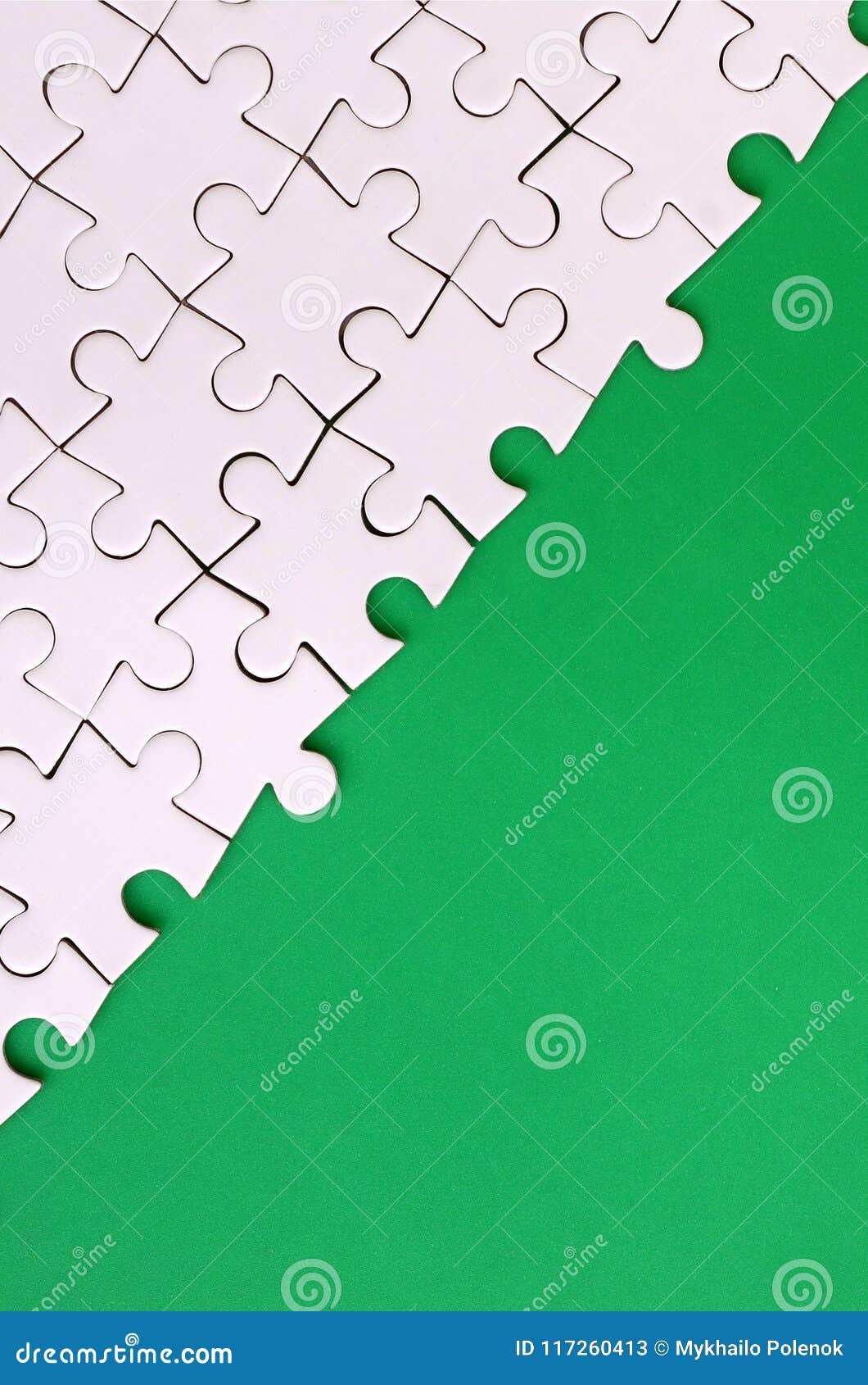 Fragment of a Folded White Jigsaw Puzzle on the Background of a Green ...