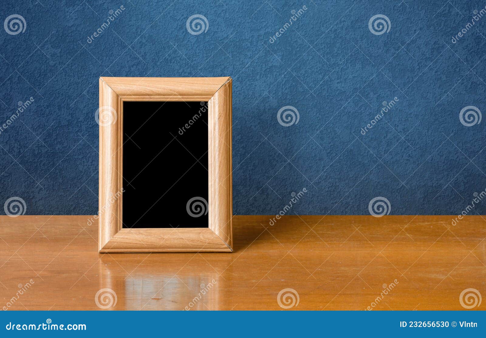 Frame on table, blue wall stock photo. Image of decoration - 232656530