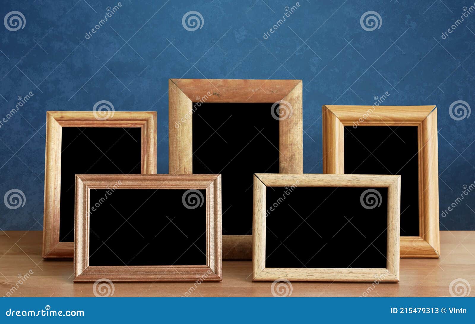 Frames on table, blue wall stock image. Image of photoframe - 215479313