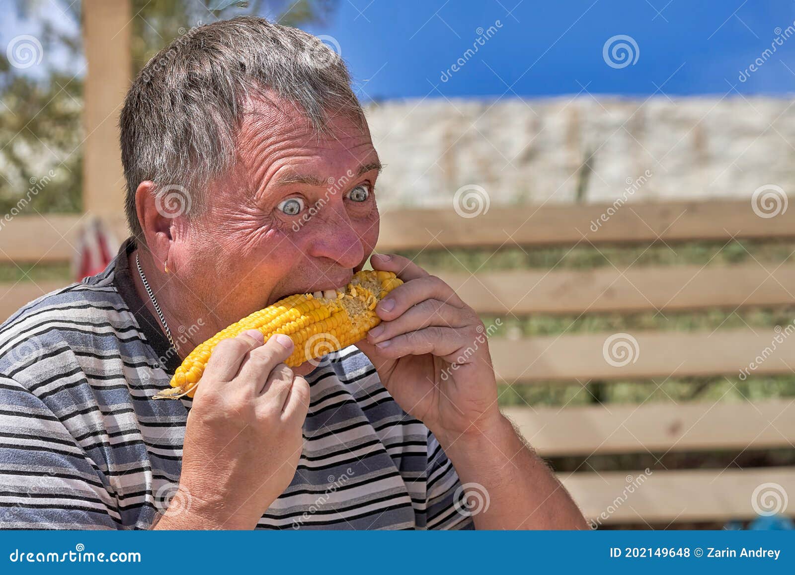 Freak with Bulging Eyes and Open Mouth Holding an Ear of Corn Stock ...