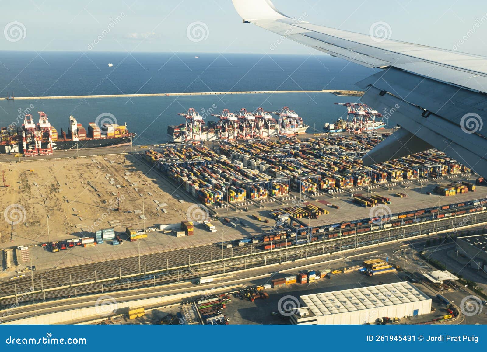 Freight Cargo Ship Loading on a Harbour Seen from an Airplane Wing ...