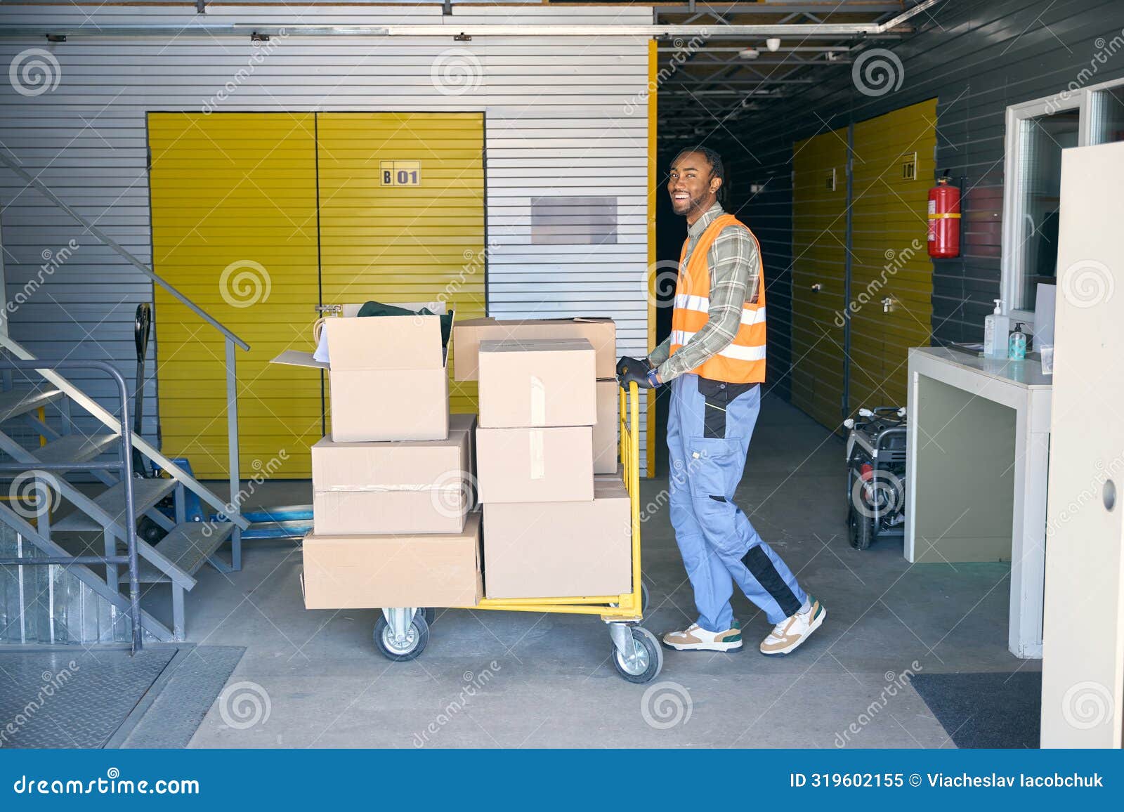 Freight Handler Transporting Goods on Wheeled Cart in Warehouse Stock ...