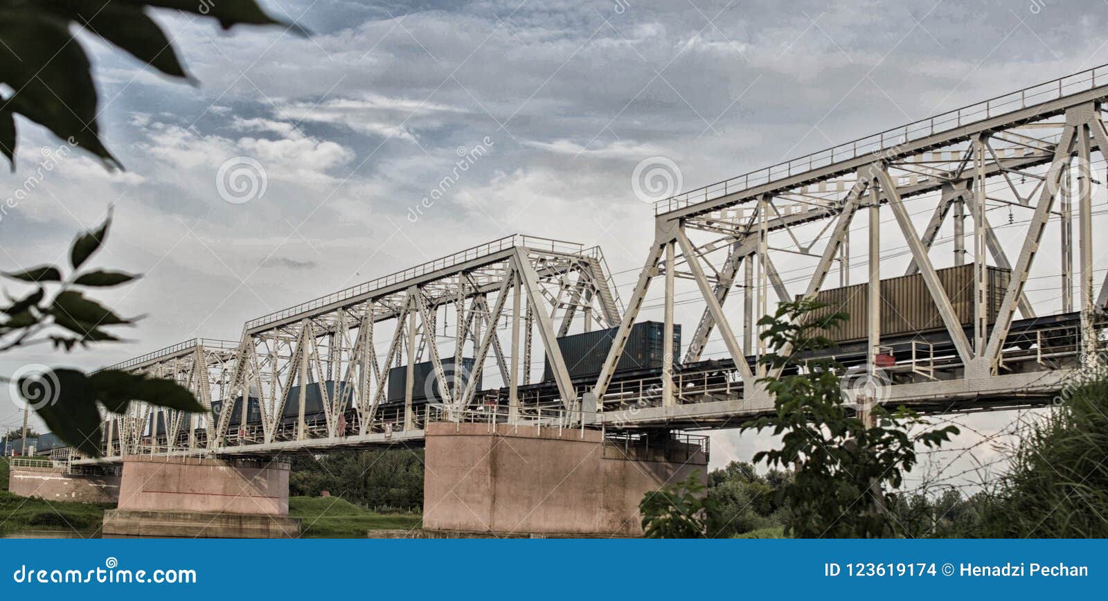 The Freight Train is Moving Along the Railway Bridge Across the River ...