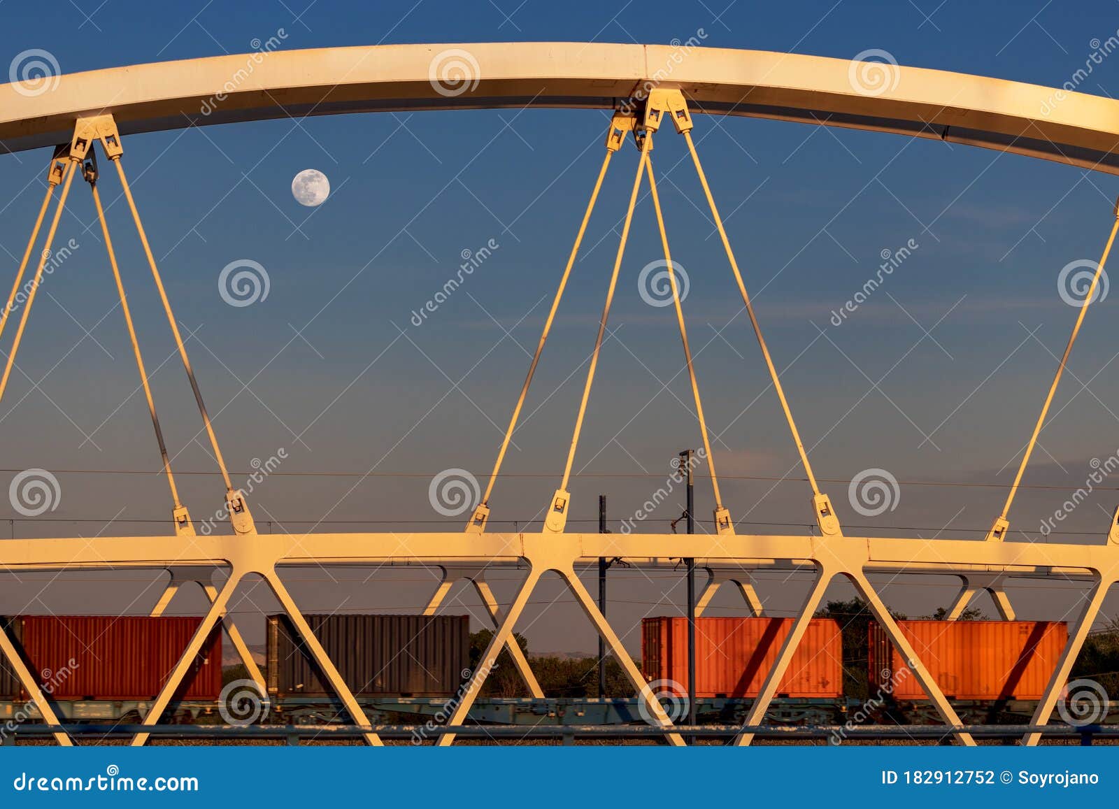 Freight Train Passing a Bridge at Sunset with the Full Moon Stock Photo ...