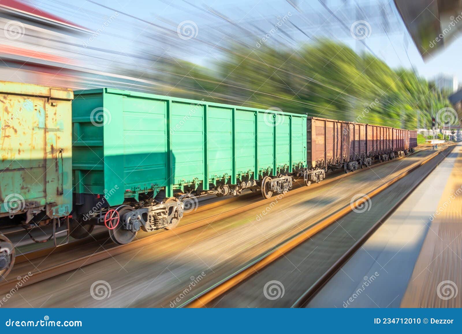 Freight Train Rushes at High Speed Past the Passenger Station Stock ...