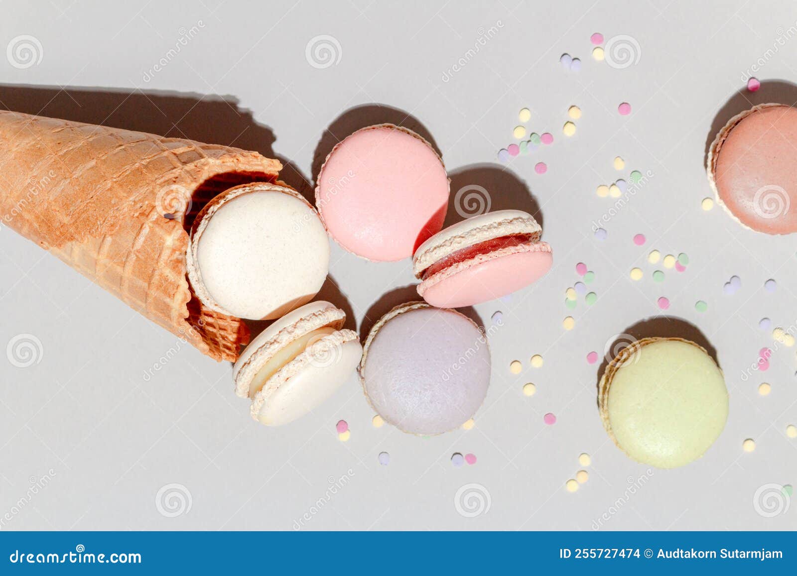 French Dessert Concept, Colorful Macarons are Served in Waffle Cone and Falling on Grey ...