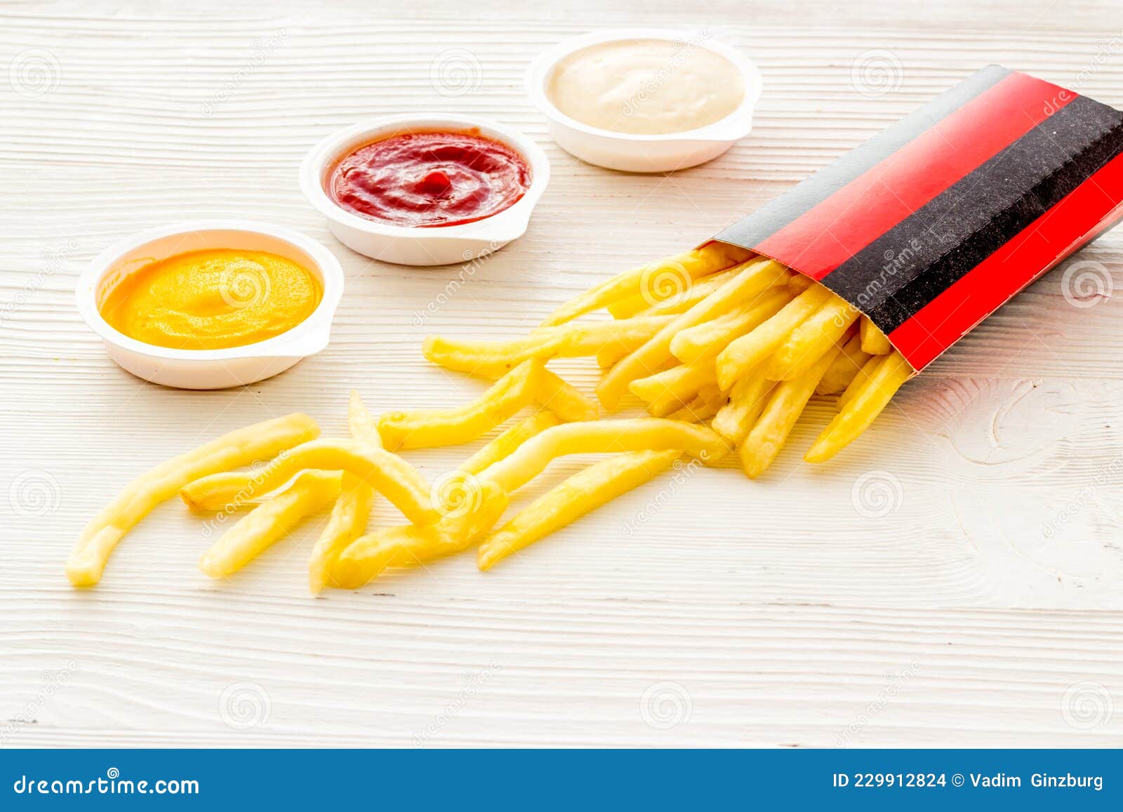 French Fries in Red Paper Wrapper with Different Sauces Stock Photo ...
