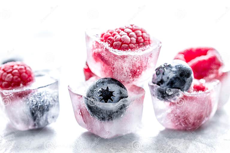 Fresh Blueberry and Raspberry in Ice on Table Background Stock Photo ...