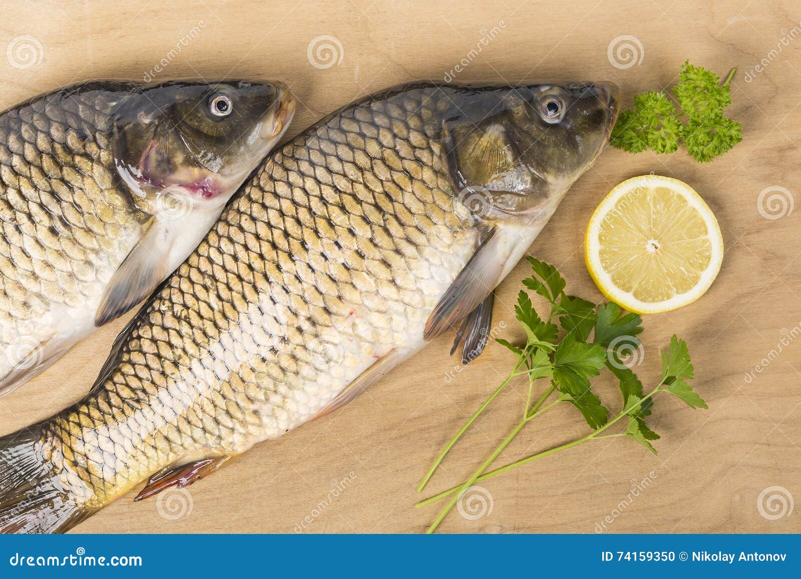 Fresh Carps with Lemon Slice and Herb on Wood Table Stock Photo - Image ...