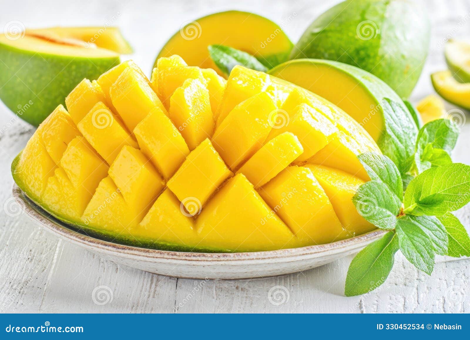 Fresh Cubed Mango on a Plate with Whole and Sliced Mangoes in ...
