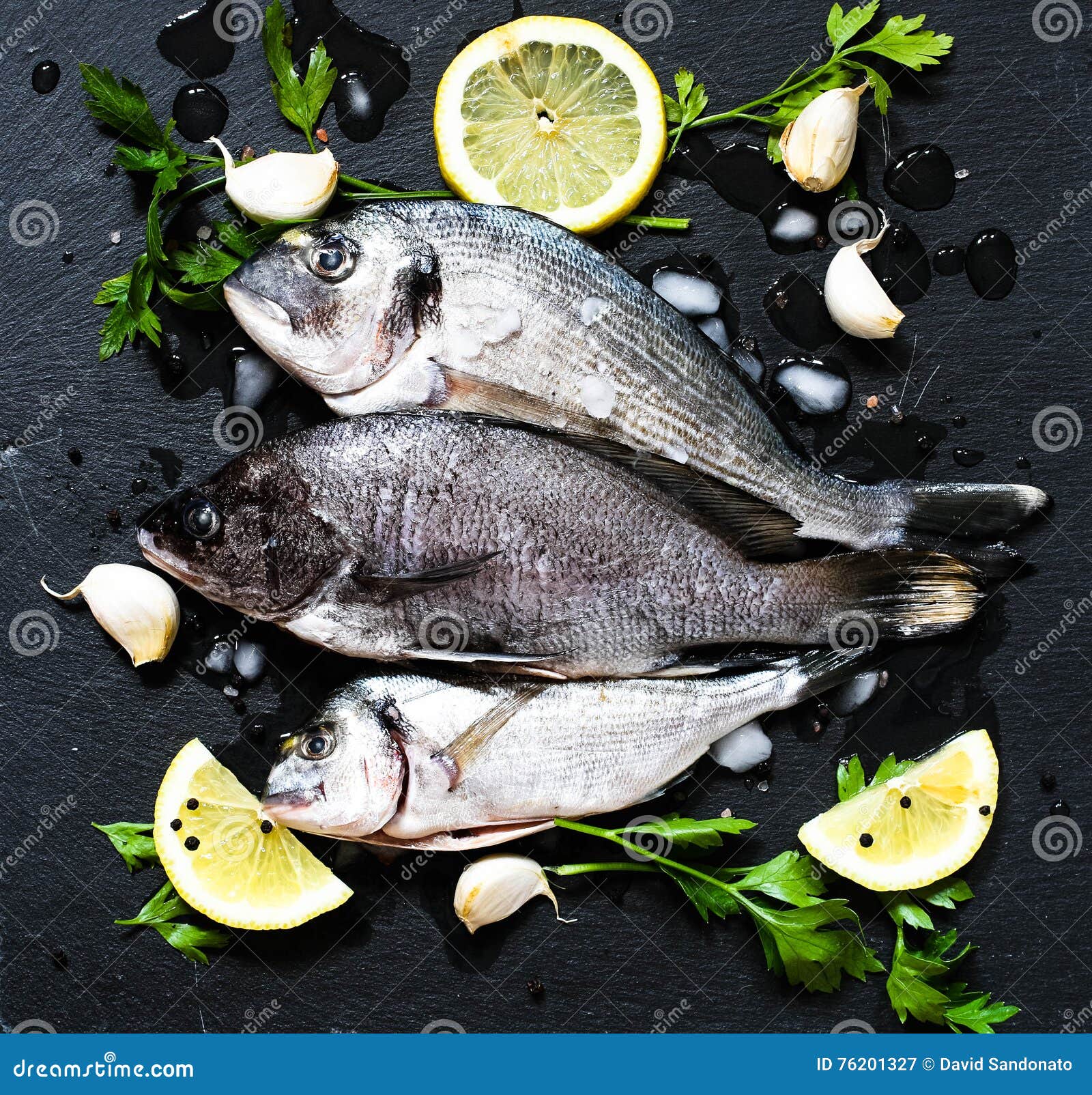 Fresh Fish Orata Over a Black Stone with Vegetables Stock Image - Image ...