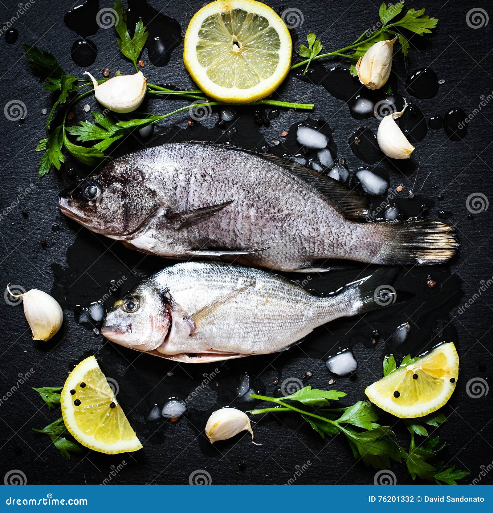 Fresh Fish Orata Over a Black Stone with Vegetables Stock Photo - Image ...