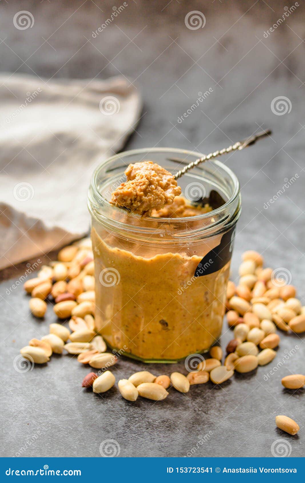 Fresh Peanut Spread in Jar and Spoon and Scattered Peanuts on Gray ...