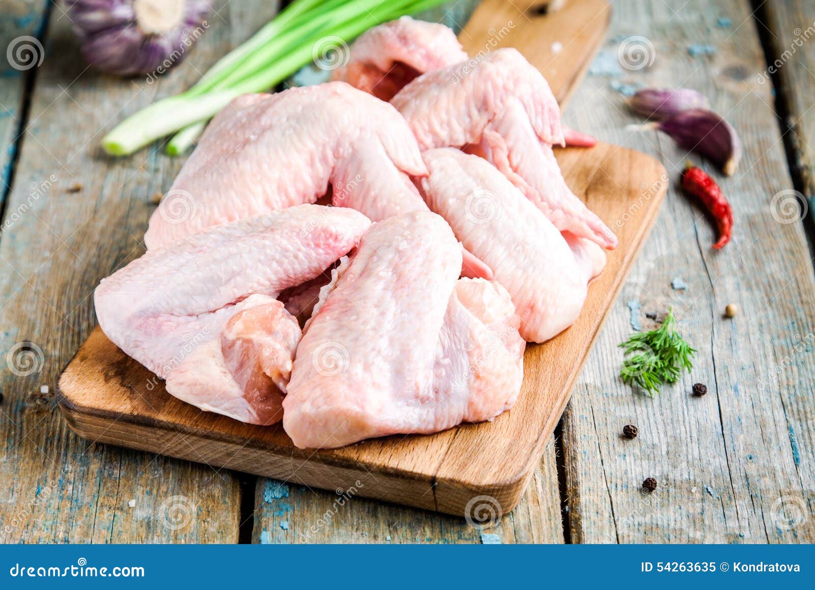 Fresh Raw Chicken Wings with Garlic, Onion and Peppers on a Cutting ...