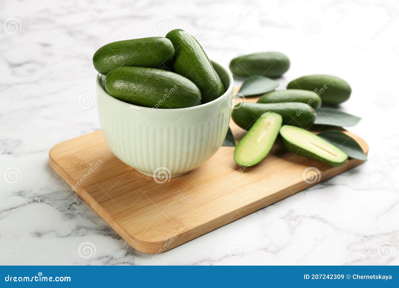 Fresh Seedless Avocados with Green Leaves on Marble Table Stock Image ...