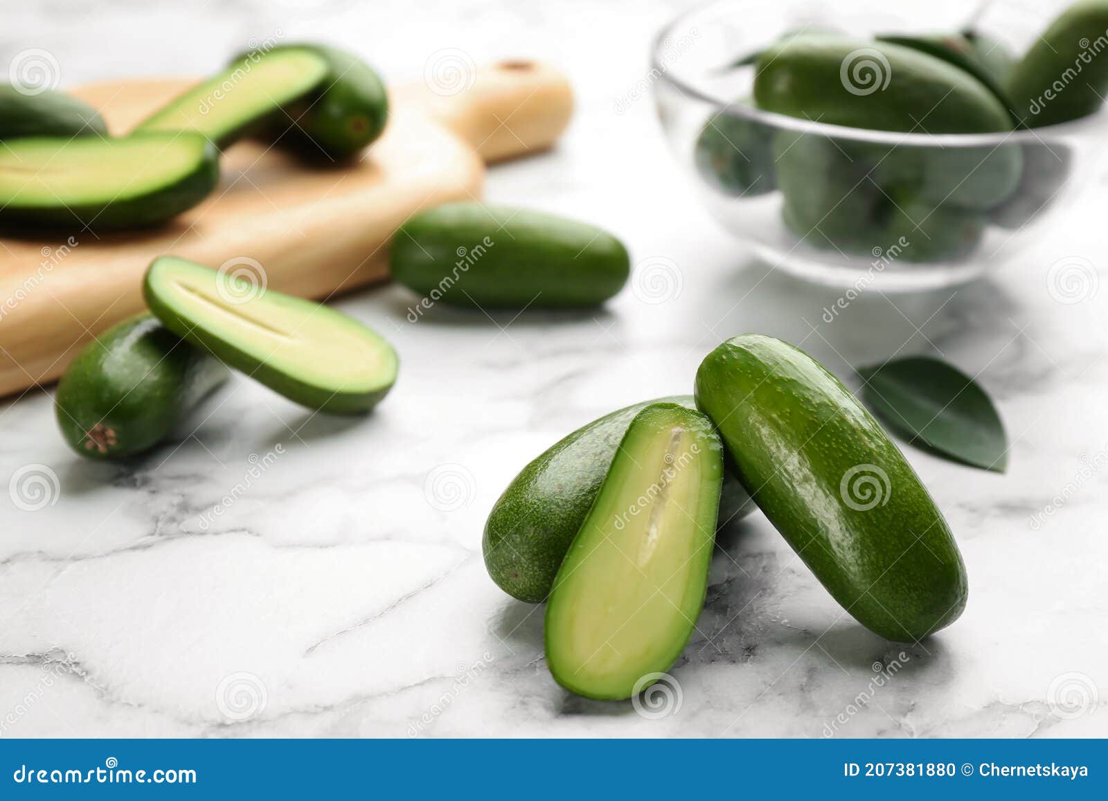 Fresh Seedless Avocados with Green Leaves on Marble Table Stock Photo ...