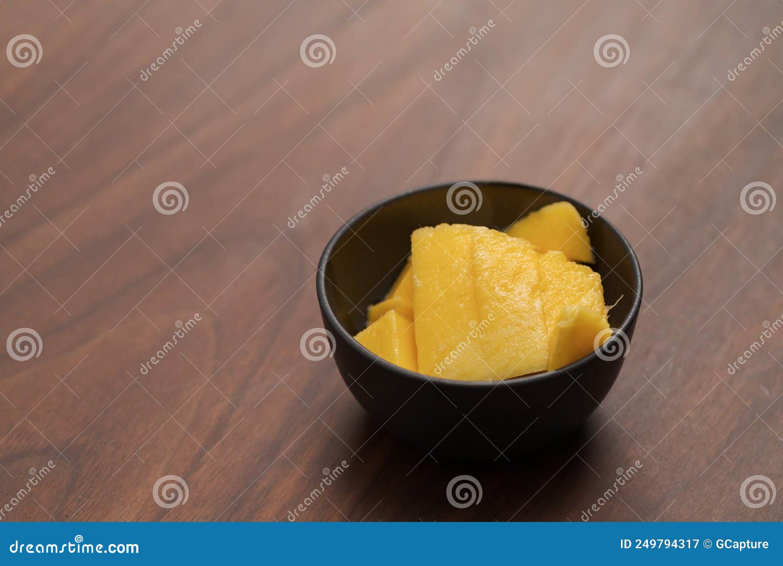 Fresh Sliced Mango in a Ceramic Bowl on Walnut Table Stock Image ...