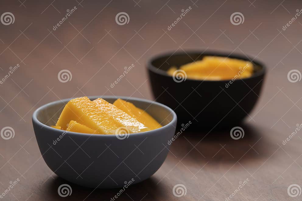 Fresh Sliced Mango in a Ceramic Bowls on Walnut Table Stock Photo ...