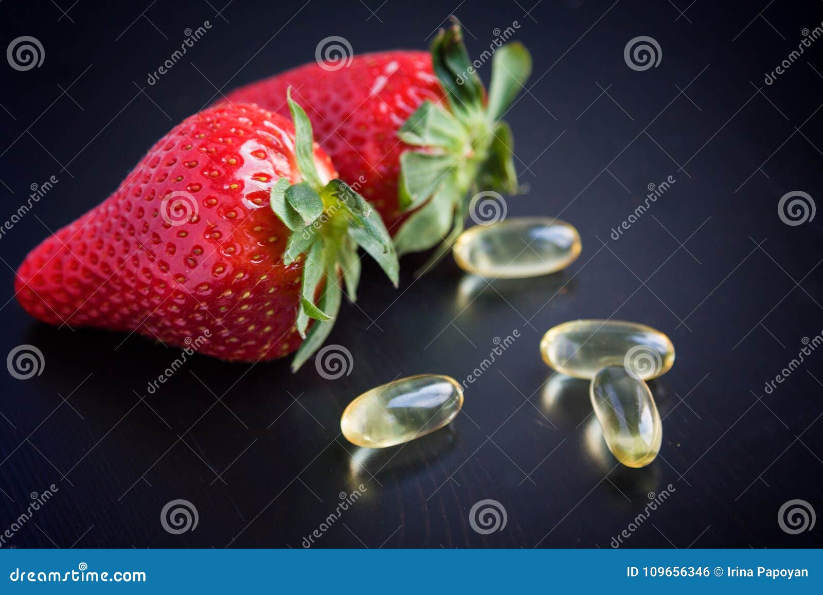 Fresh Strawberries and Capsules of Fish Oil on Black Stock Photo ...
