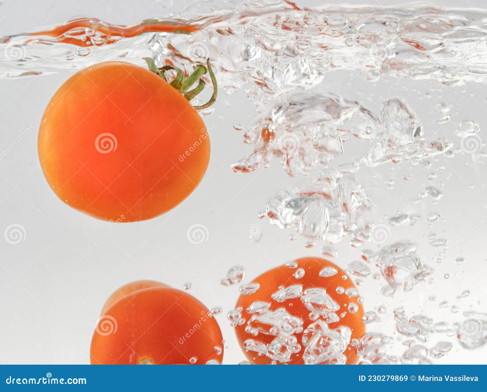 Fresh Tomatoes are Thrown into the Water with Splashes. Close-up ...
